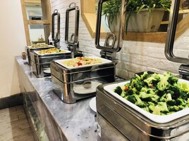 Buffet com diversos pratos, incluindo frutos do mar, massas e legumes.
