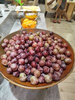 Uma tigela grande cheia de uvas sobre um balcão de mármore.