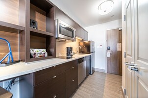 Um frigorífico/congelador grande, um micro-ondas, uma cafeteira/bule 