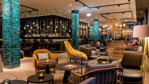 Uma área de estar moderna com assentos, bar e iluminação decorativa.