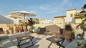Terraço no terraço com área de estar ao ar livre, incluindo sofás, cadeiras e mesas.