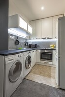 Apartamento superior, várias camas, vista para o jardim | Cozinha privada | Fogão, cooktop, lava-louças, chaleira elétrica