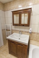 Apartamento superior, várias camas, vista para o jardim | Comodidades do banheiro | Banheira, secador de cabelo, chinelos, toalhas de banho