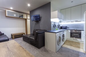 Apartamento superior, várias camas, vista para o jardim | Área de estar | TV LED 32 polegadas com canais de TV premium, TV