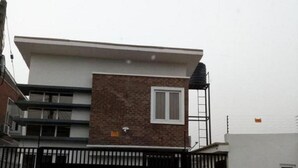 Uma casa moderna de dois andares com garagem, fachada de tijolo e portão de metal.
