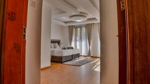 Um quarto com uma cama, uma mesa de cabeceira e uma janela com cortinas.
