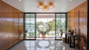 Um interior moderno com lambris de madeira, uma grande porta de vidro que dá para o exterior e um lustre.