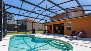 Piscina coberta ao ar livre com vista clara para os edifícios próximos e área de estar com cadeiras.