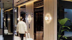 Um interior moderno com piso de mármore polido, lambris de madeira e iluminação embutida.