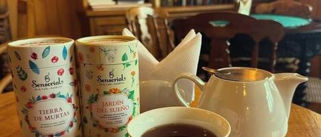 Uma mesa com uma xícara de café, um bule e duas latas de café.