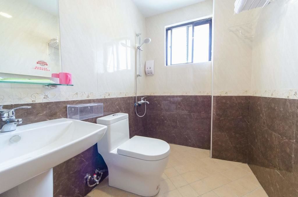 Uma casa de banho com lavatório, sanita e chuveiro.