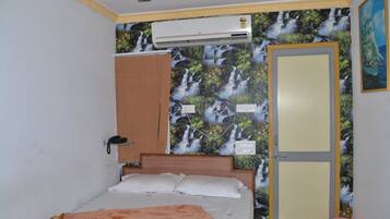 Quarto com cama, ar condicionado, porta e parede com papel de parede com tema natureza.