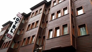 Um edifício de vários andares com design arquitetônico moderno, apresentando uma série de varandas e amplas janelas.