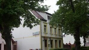Um edifício de dois andares com uma placa indicando que é um restaurante.
