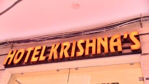 Placa de hotel com o nome 'HOTEL KRISHNA'S'.