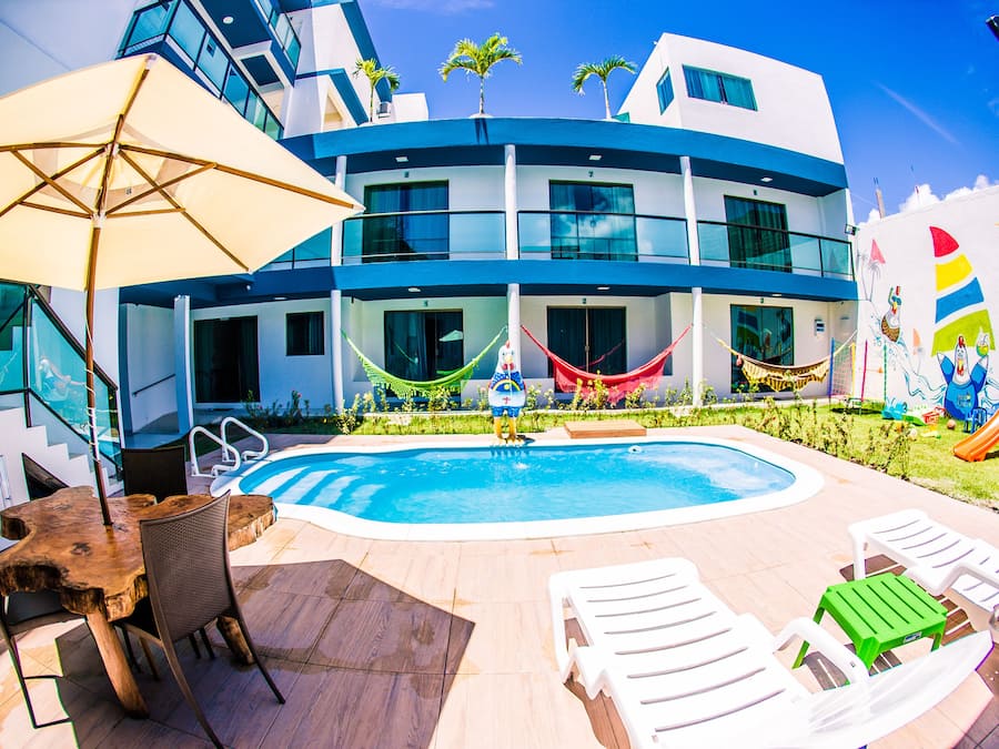 Um edifício moderno com piscina, área de estar externa e um mural colorido.