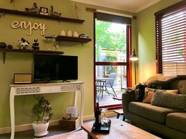 Apartamento, 1 cama king-size, vista para o jardim | Sala de estar | Televisor de ecrã plano de 35 polegadas com canais digitais, televisor