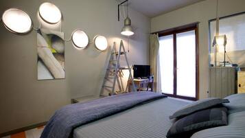 Quarto com cama, escrivaninha, escada e uma janela grande.