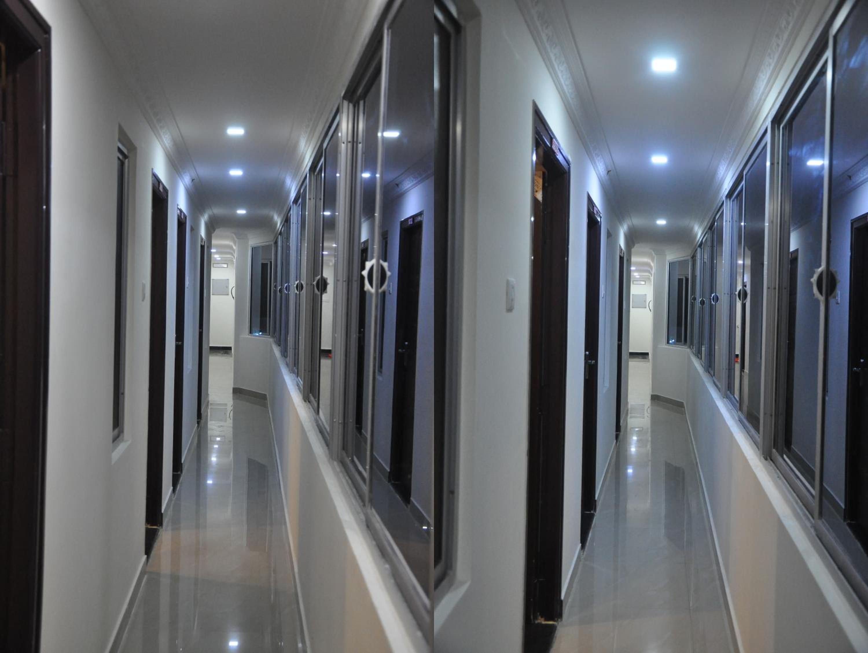 Corredor comprido e estreito, com portas em ambos os lados, dando acesso a quartos individuais.
