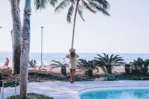 Na praia, espreguiçadeiras, guarda-sóis de praia, toalhas de praia