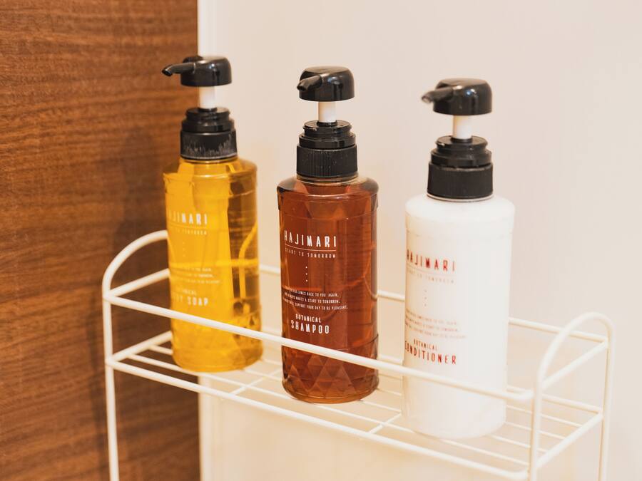 Estante metálica branca com três frascos de produtos Hajimari.