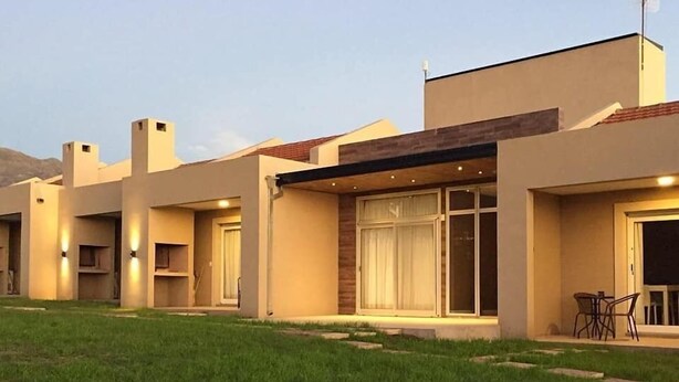 Uma casa moderna com um alpendre coberto e um gramado.