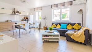 Uma sala de estar moderna com sofá, mesa de centro e área de jantar.