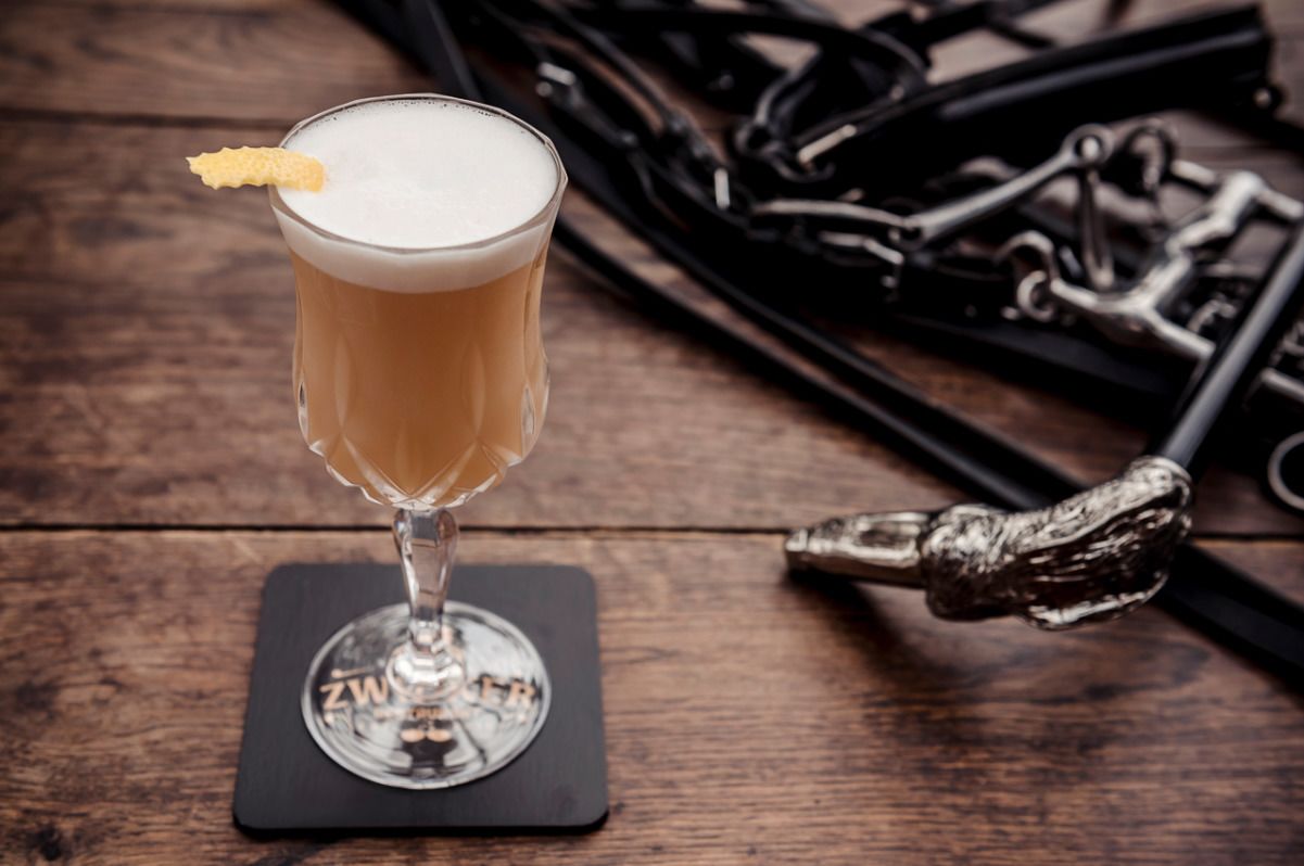 Um copo de cerveja com espuma e uma rodela de limão.