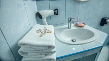 Um chuveiro fixo, artigos de higiene pessoal grátis, toalhas fornecidas