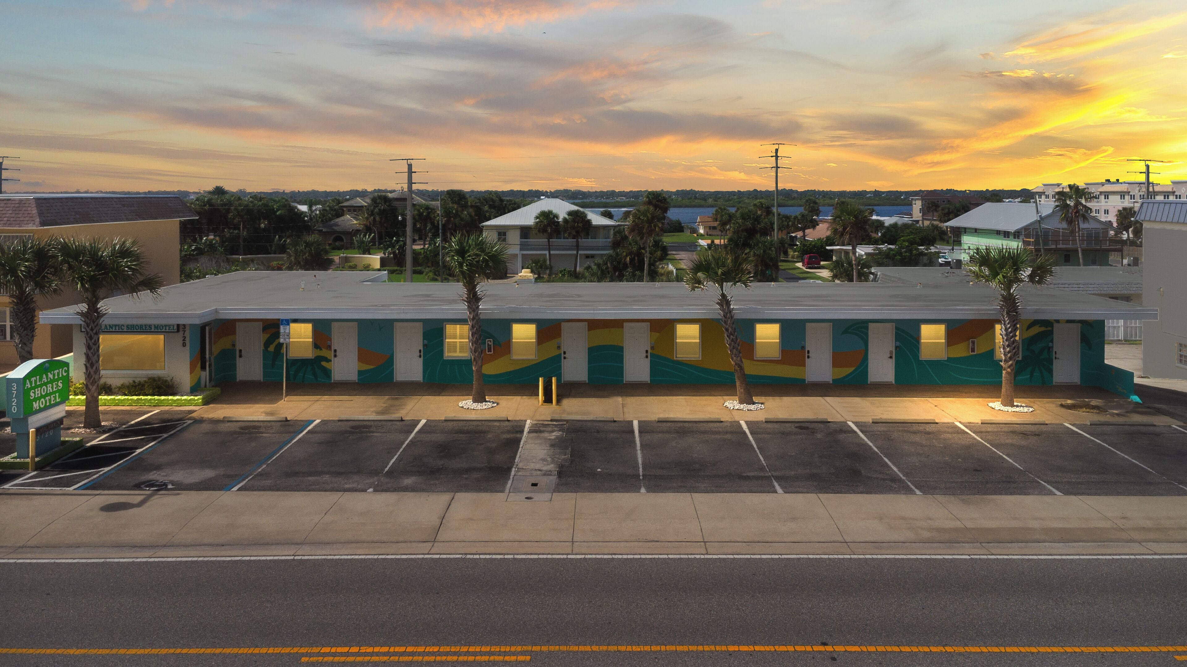 Um motel com teto plano, várias portas e um estacionamento.