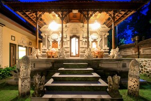 Um templo com um altar central, estátuas de pedra e uma escadaria que o conduz.