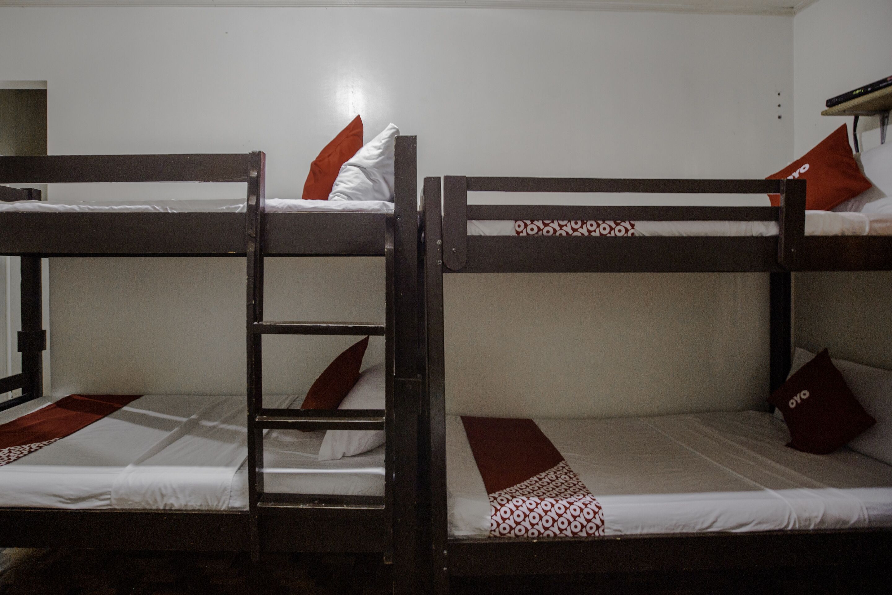 Quarto tipo dormitório com beliches, cada um com travesseiro e colcha estampada.