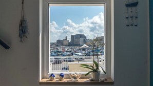Uma janela com vista para uma marina e edifícios da cidade.