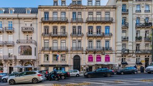 Um edifício histórico com várias varandas e uma entrada central.