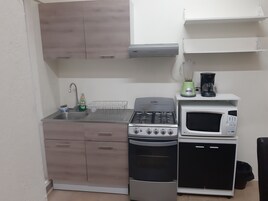 Loft executivo, 2 quartos, cozinha americana, no piso térreo | Cozinha privada | Geladeira, talheres/pratos/utensílios de cozinha