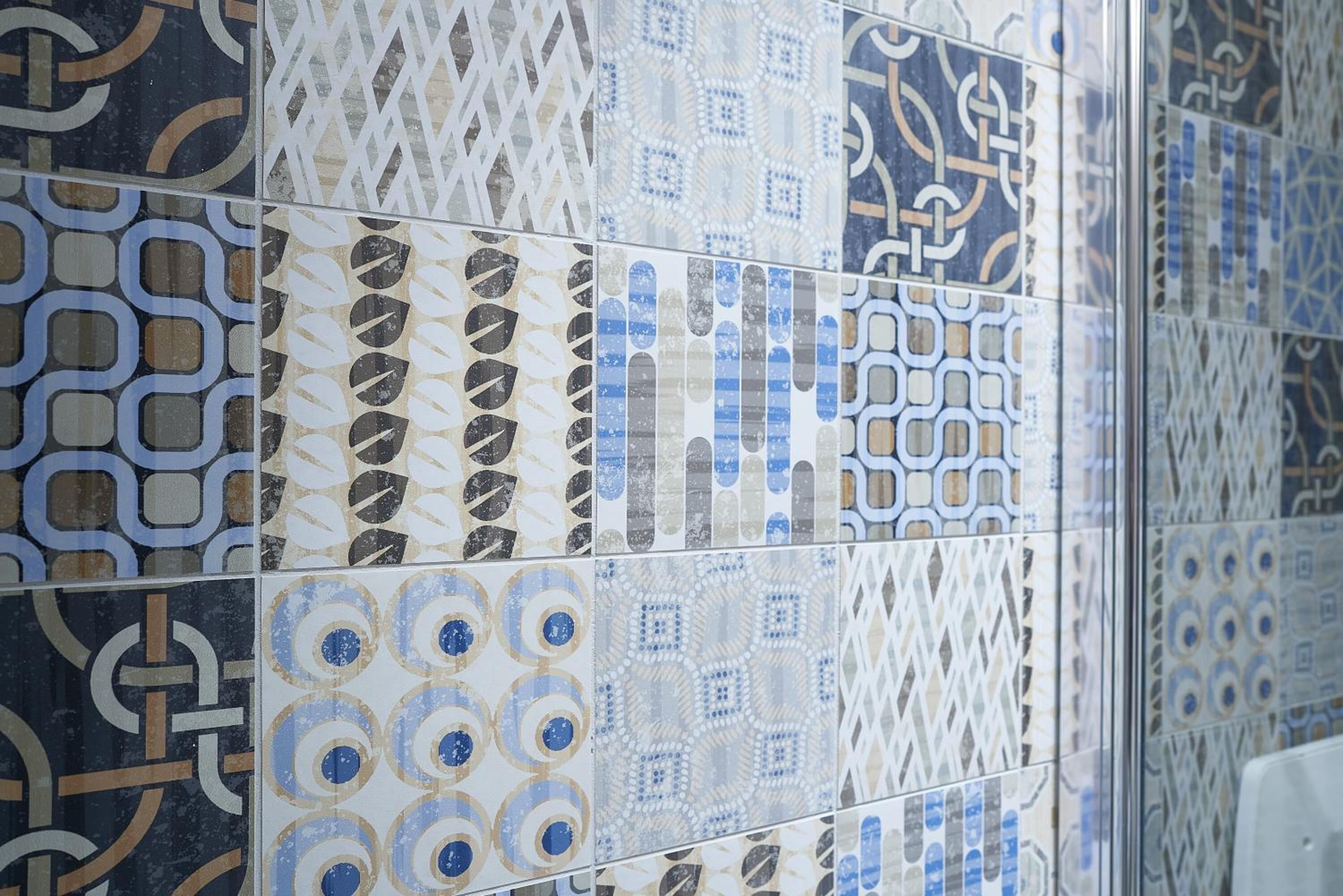 Uma parede com diversos azulejos estampados, em diferentes designs e cores.