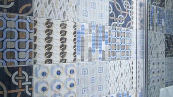 Uma parede com diversos azulejos estampados, em diferentes designs e cores.