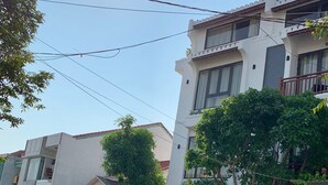 Um grupo de pessoas andando de bicicleta em uma rua com prédios residenciais.