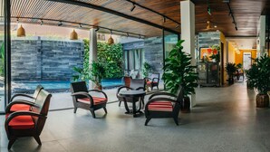 Um pátio interno moderno com paredes de pedra, piscina e áreas de estar confortáveis.