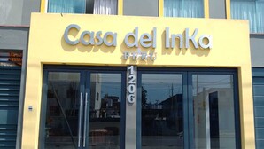 Exterior da Casa del Inka, com fachada amarela, grandes portas de vidro e o número do endereço visível.