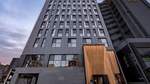 Um edifício alto e moderno com uma grade de janelas e uma seção de fachada em madeira.