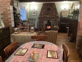 Uma área de jantar acolhedora com uma mesa redonda, cadeiras e toalha de mesa estampada.