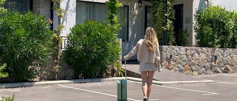 Uma mulher caminhando em direção a um edifício com uma placa que diz 'RECEPTION'.