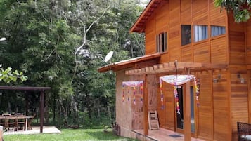 Uma casa de madeira com varanda coberta e um caminho de pedra que leva à entrada.