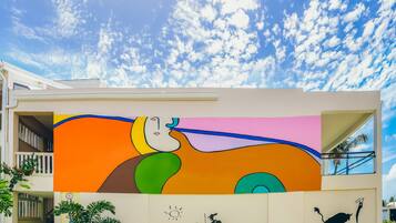 Um edifício com um mural colorido e uma varanda.
