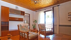 Uma sala de estar acolhedora com móveis de madeira, um candelabro e vista para o exterior.