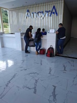 Uma receção com uma placa a indicar "Ancyra" num edifício moderno com chão de mármore.