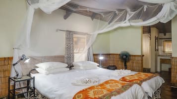 Uma cama com dossel, abajures e mesa de cabeceira.