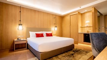 Quarto de hotel moderno com uma cama grande, paredes de painel de madeira e um tapete estampado com padrão de zebra.