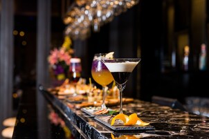 Um bar com diversas bebidas e guarnições no balcão.